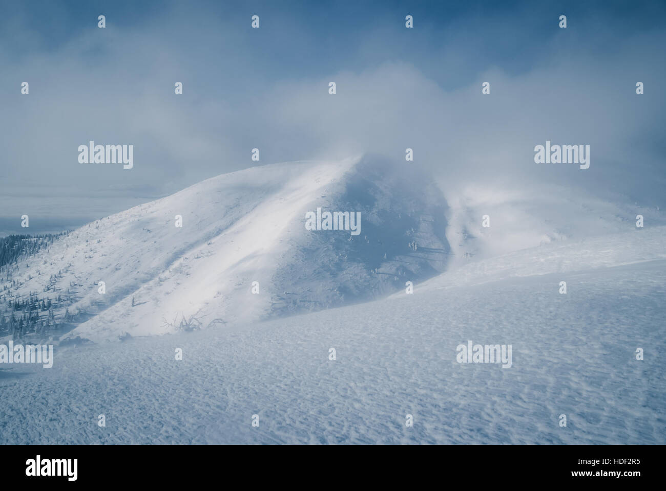Photo of mountains covered in fog and snow during winter in High Tatras ...