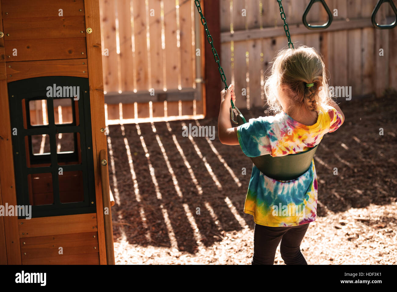 Top view of girl on swing on playground. back view Stock Photo - Alamy