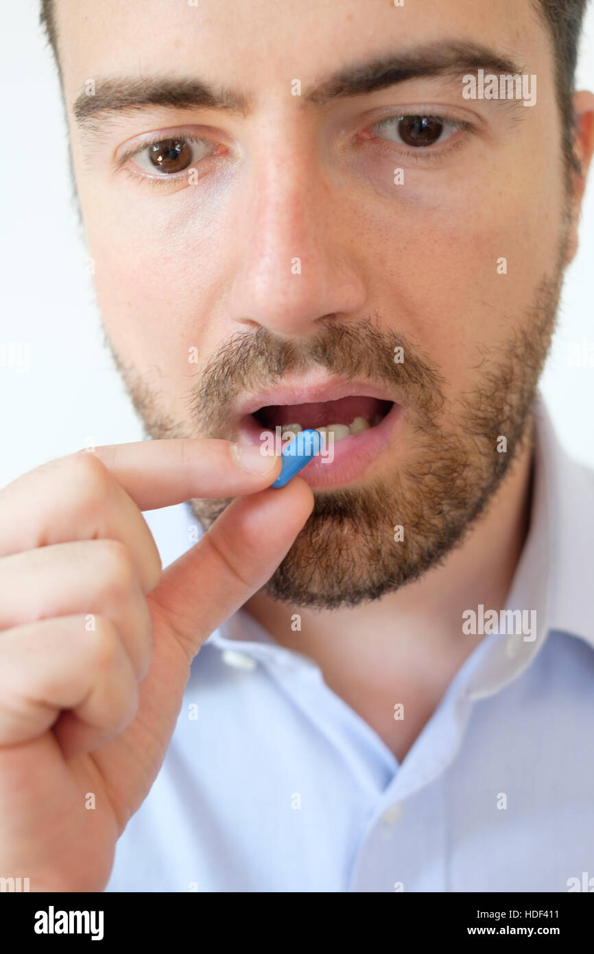 Portrait of Young adult taking a pill Stock Photo - Alamy