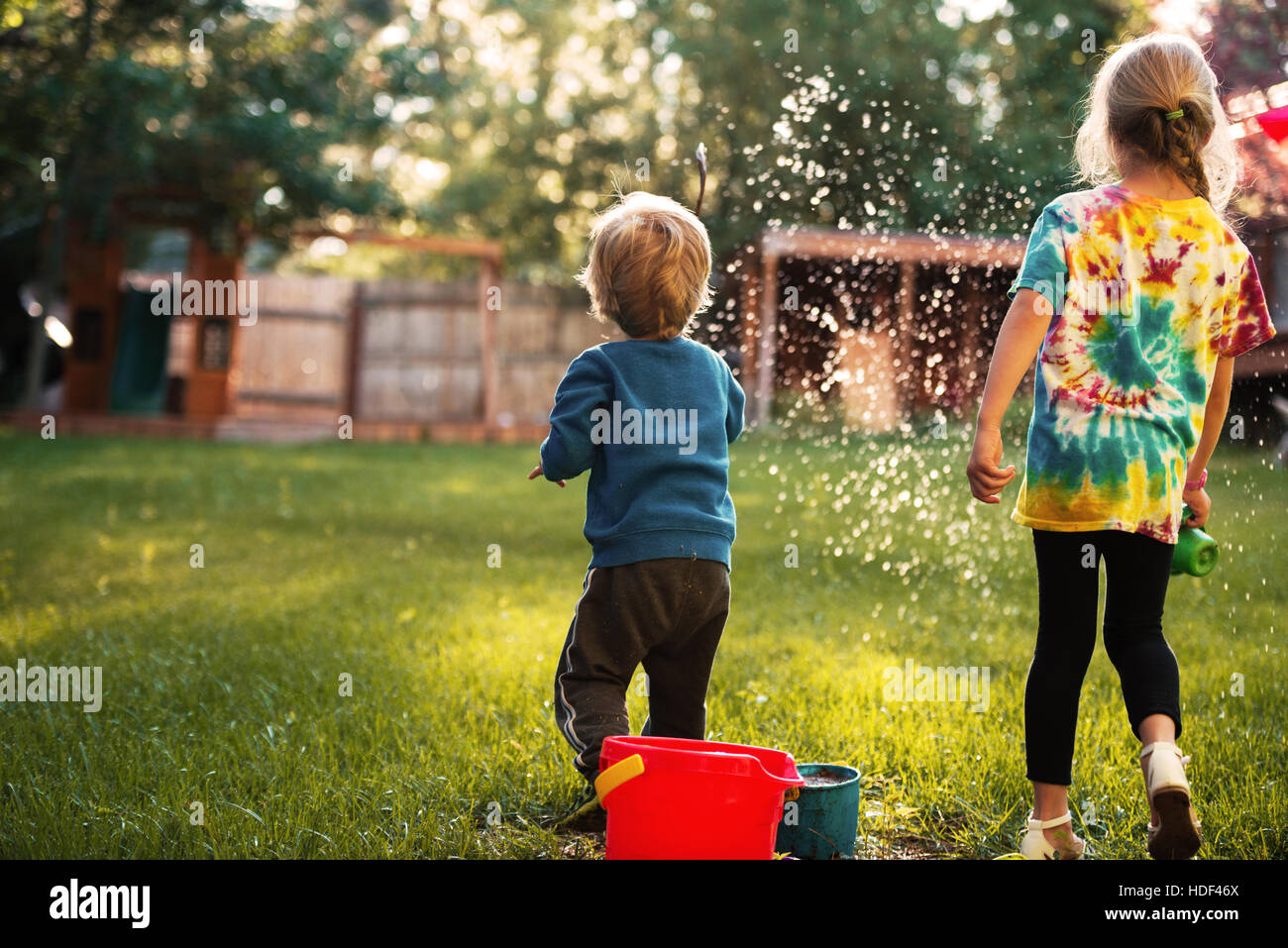 Back view of boy and girl on playground. on grass Stock Photo - Alamy