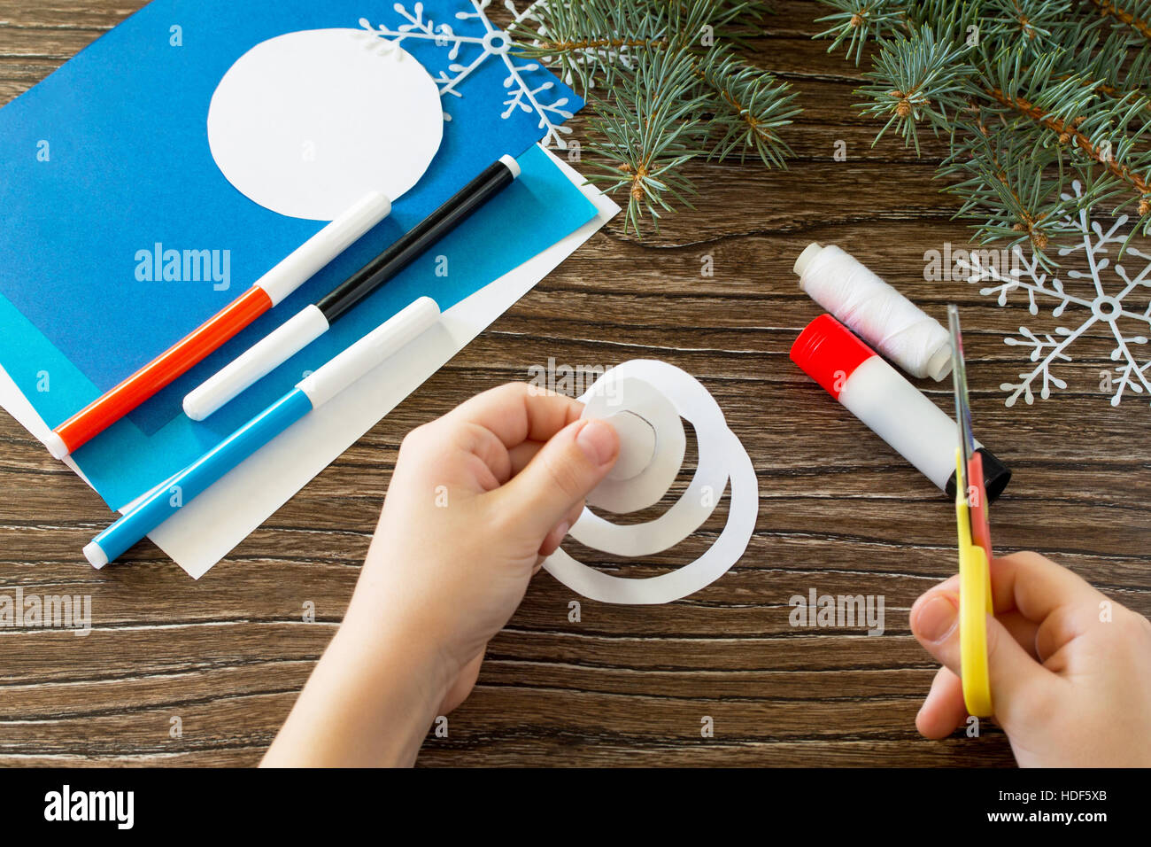 Child toy on the Christmas tree cut out paper snowman. Glue, paper ...