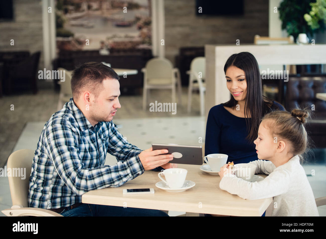 Family Enjoying tea In Cafe Together Stock Photo - Alamy