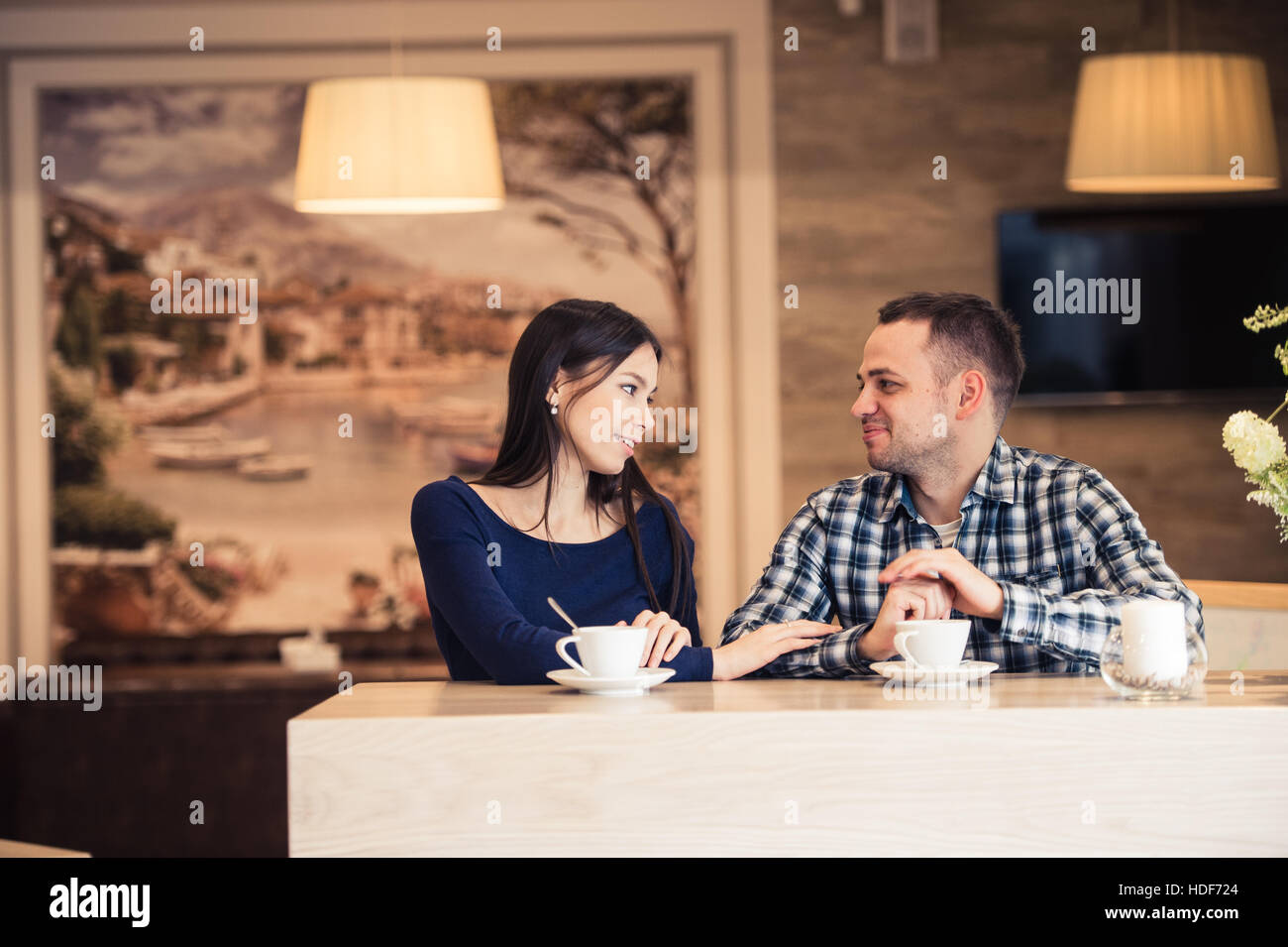 Young couple talking in coffee shop Stock Photo - Alamy