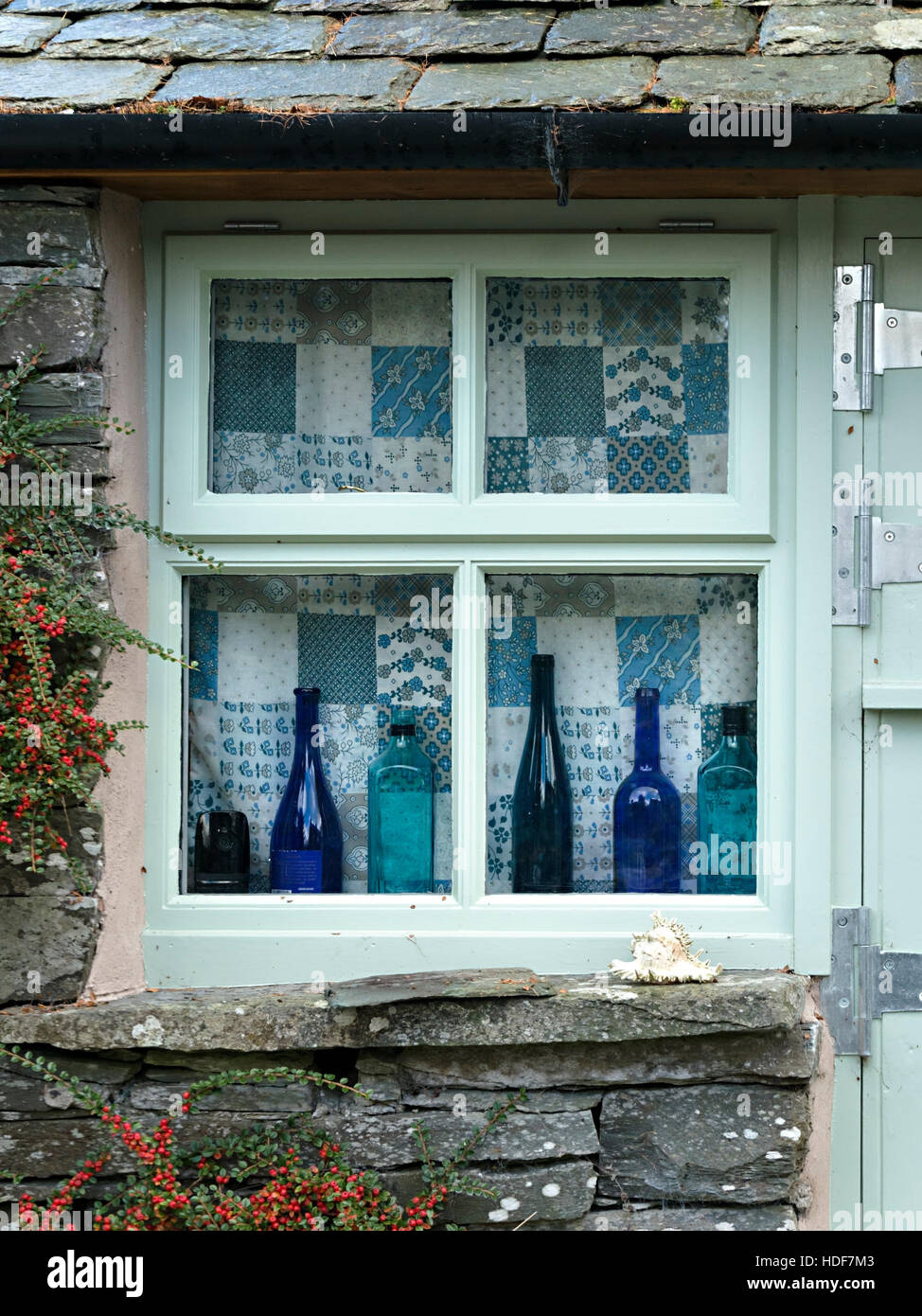 Old, pretty Lakeland slate cottage window with blue bottles & patchwork ...