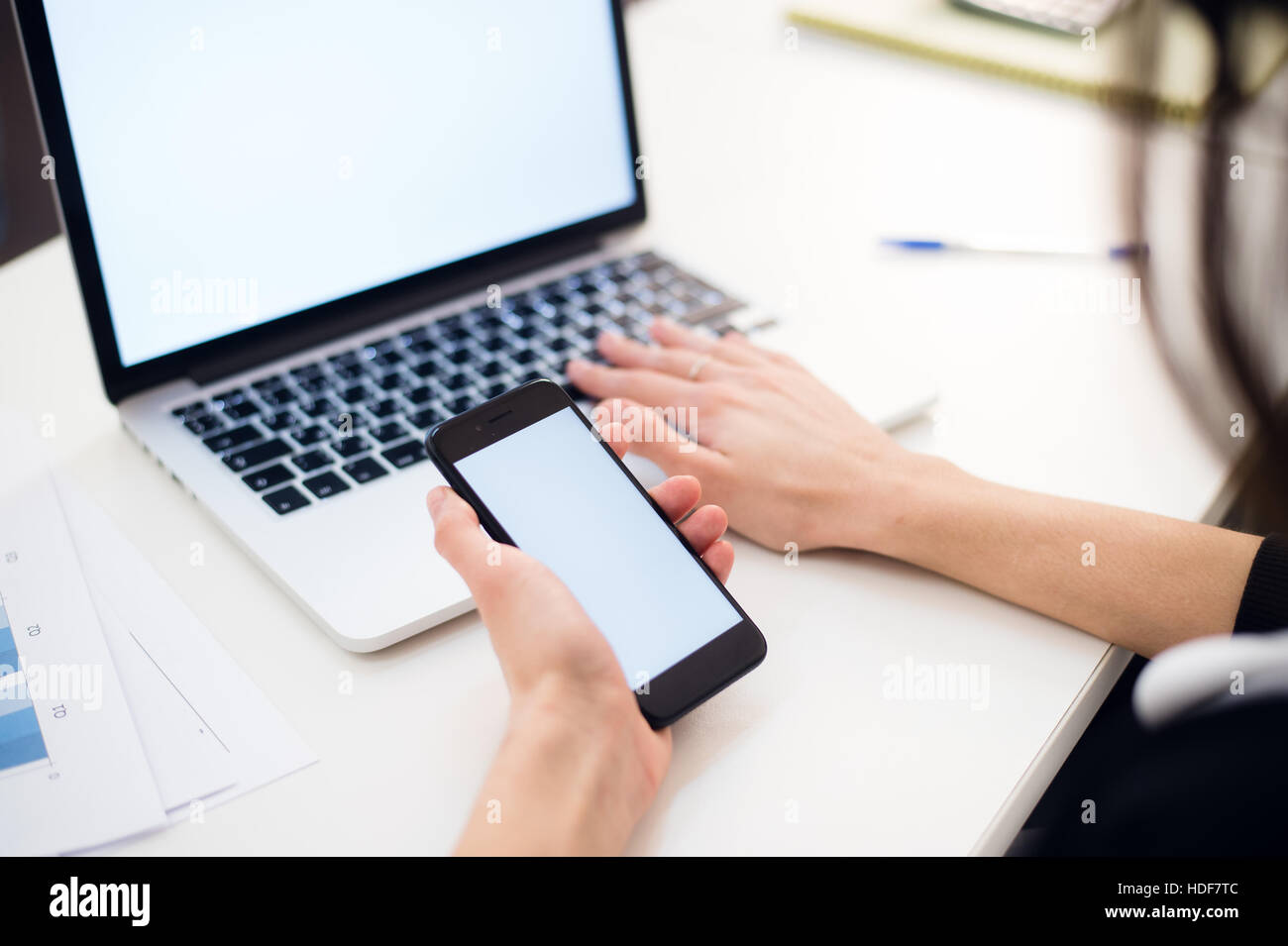 Woman's hands using mobile phone and laptop at the office Stock Photo ...