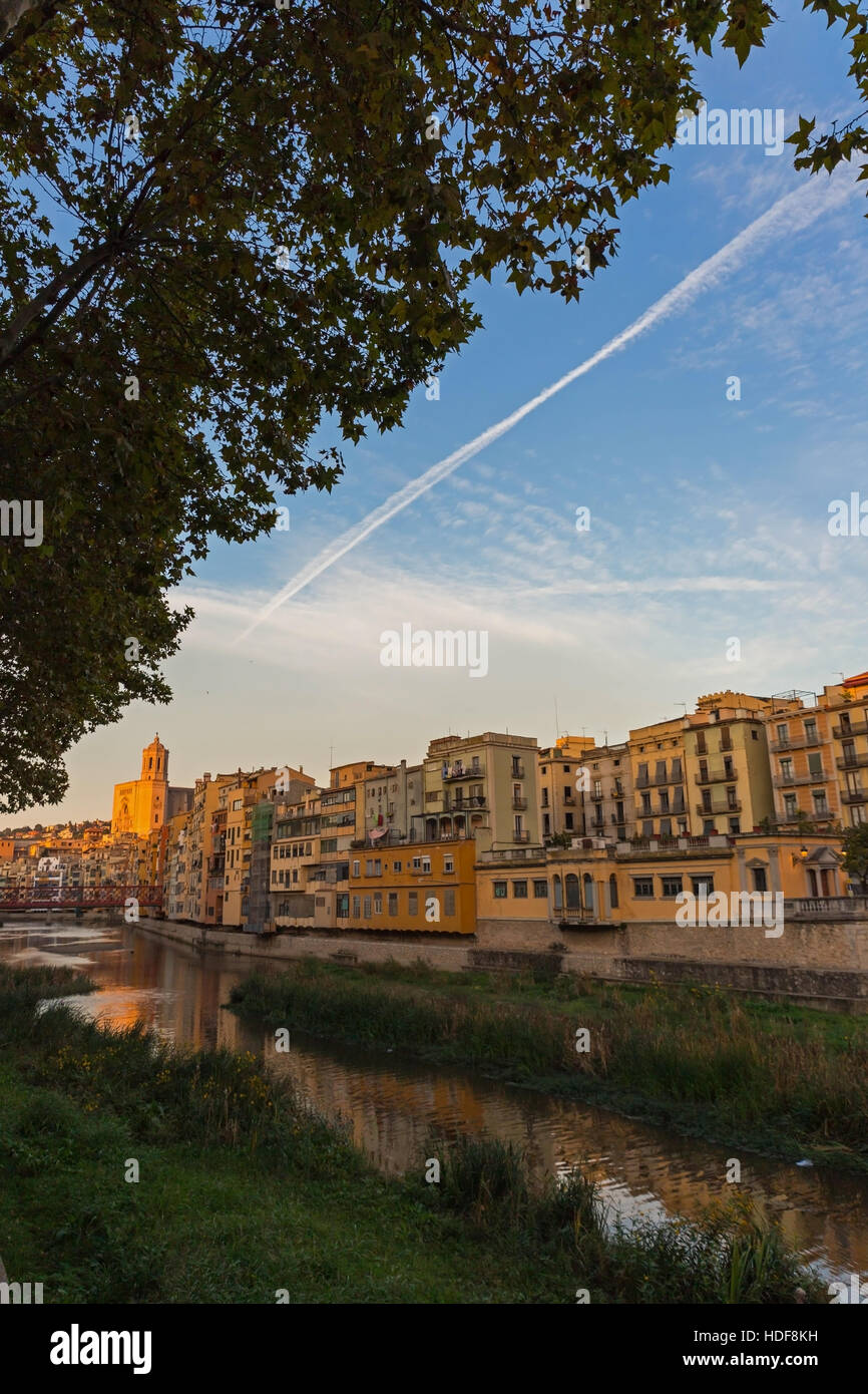 Onyar river crossing the downtown of Girona with bell tower of Basilica ...