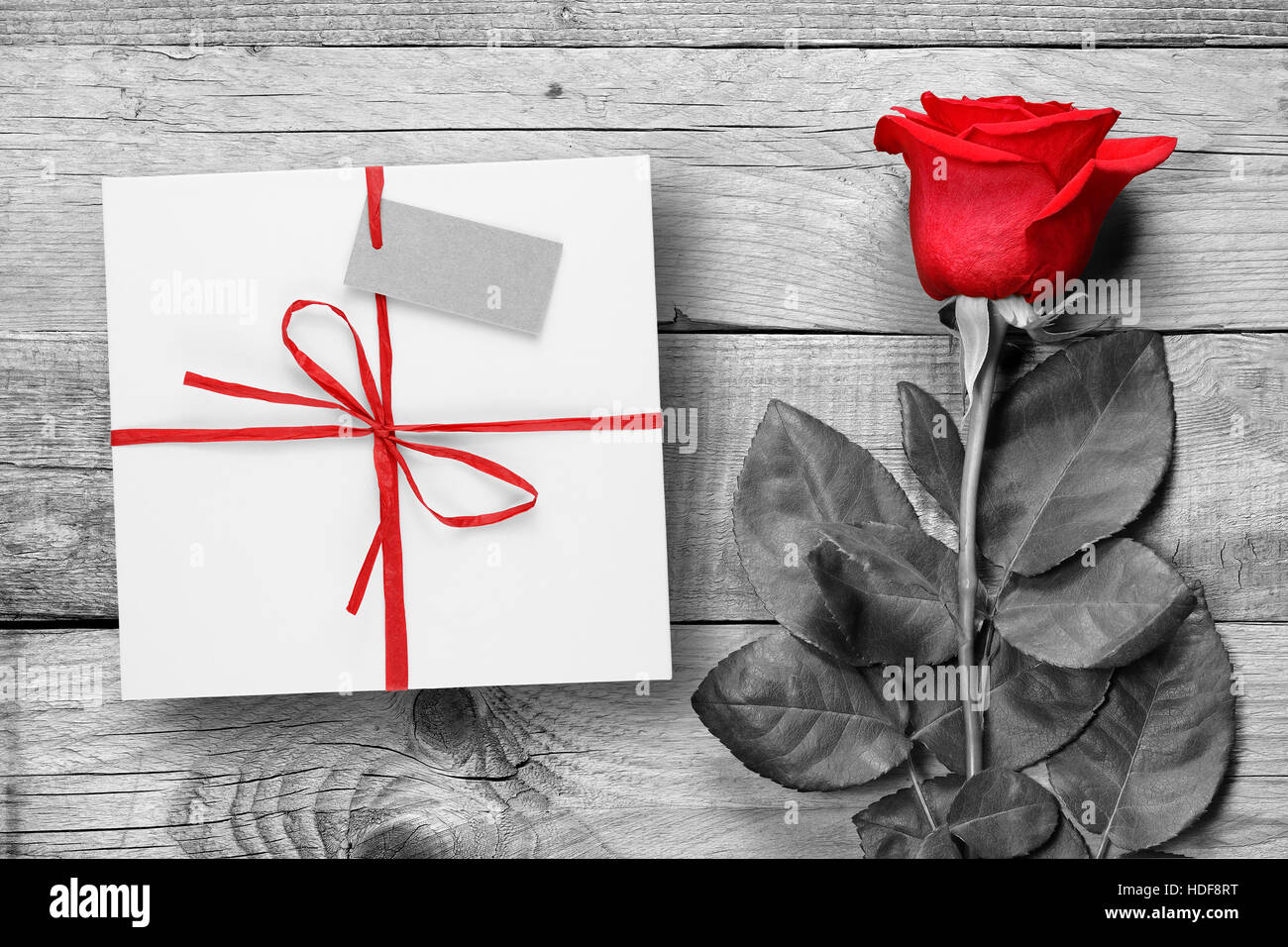 Red rose and gift box on black and white wooden background Stock Photo ...