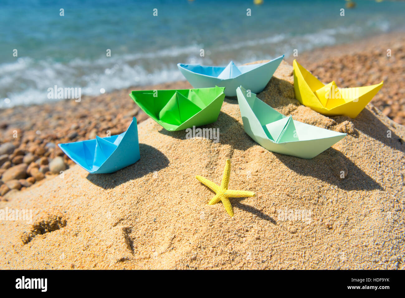 Colorful paper boats in the sand at the beach Stock Photo - Alamy