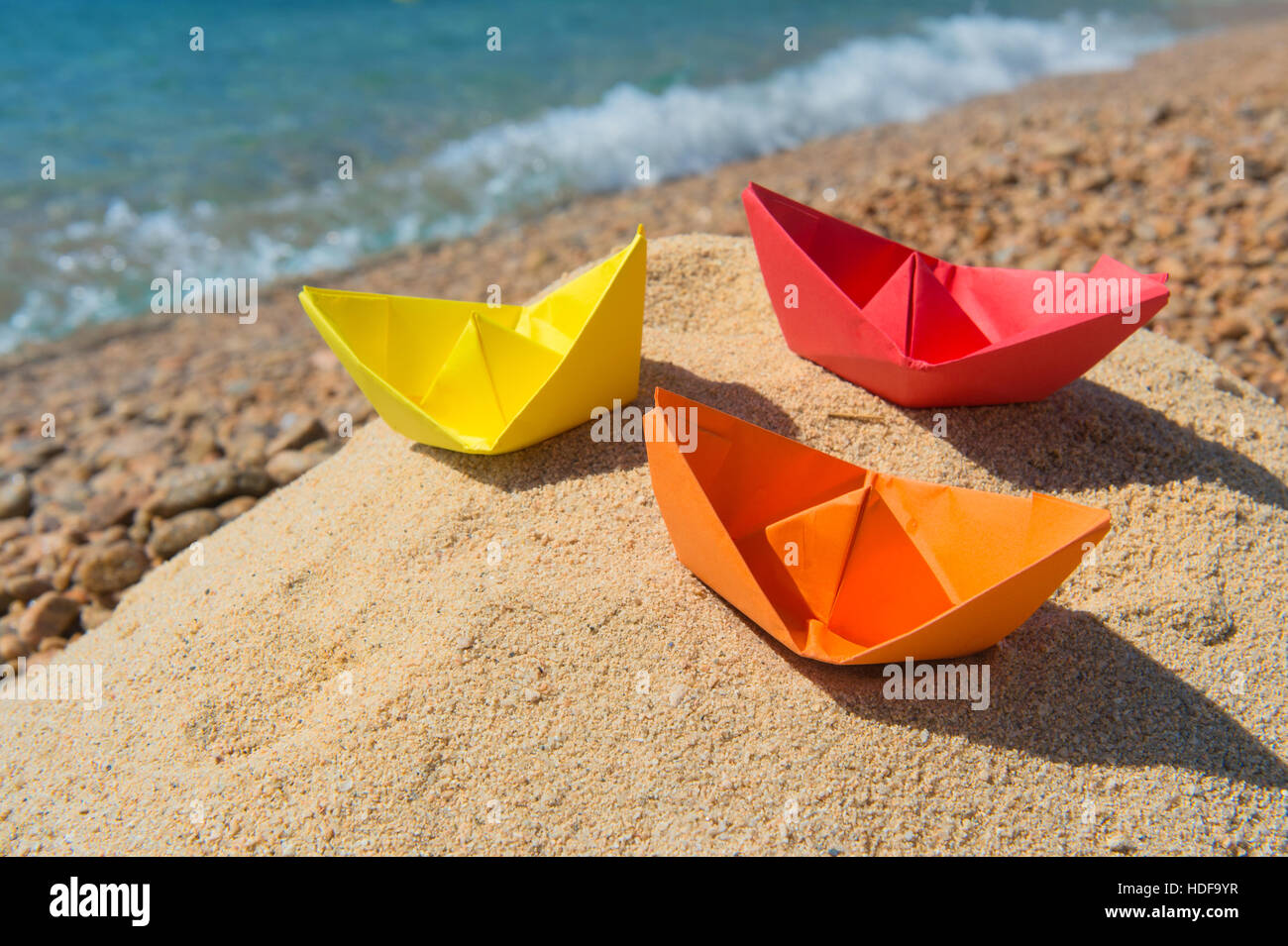 Paper boats in the sand at the beach Stock Photo - Alamy