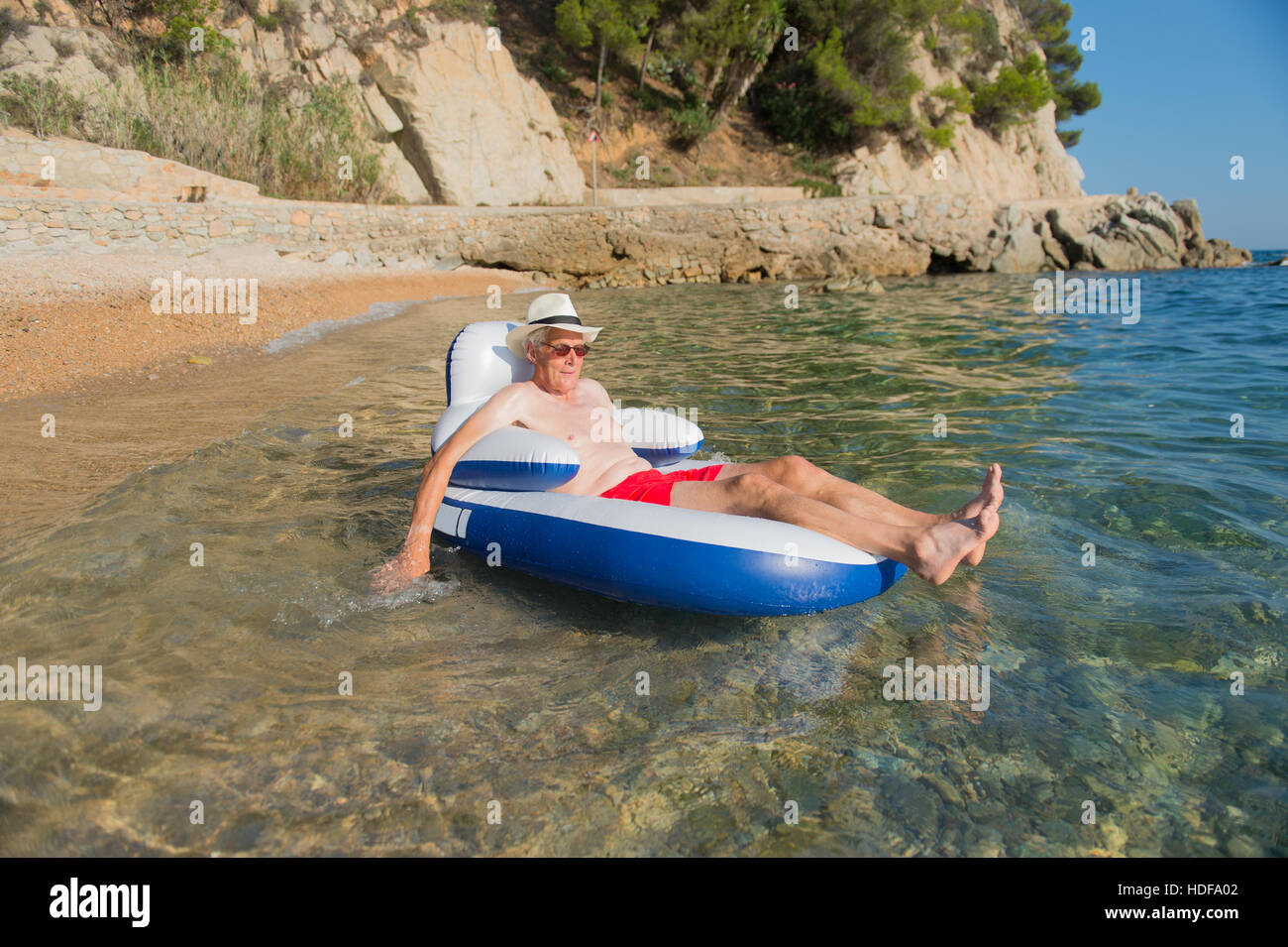 Senior man on vacation floating on chair in the sea Stock Photo - Alamy