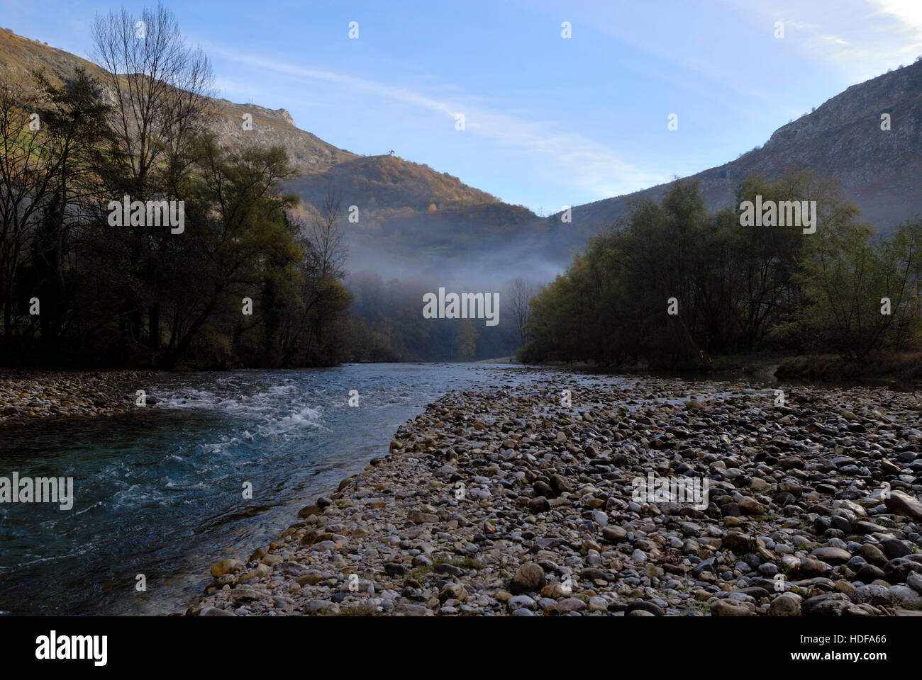 River passage through a cobbled area, in the middle of nature, with fog ...