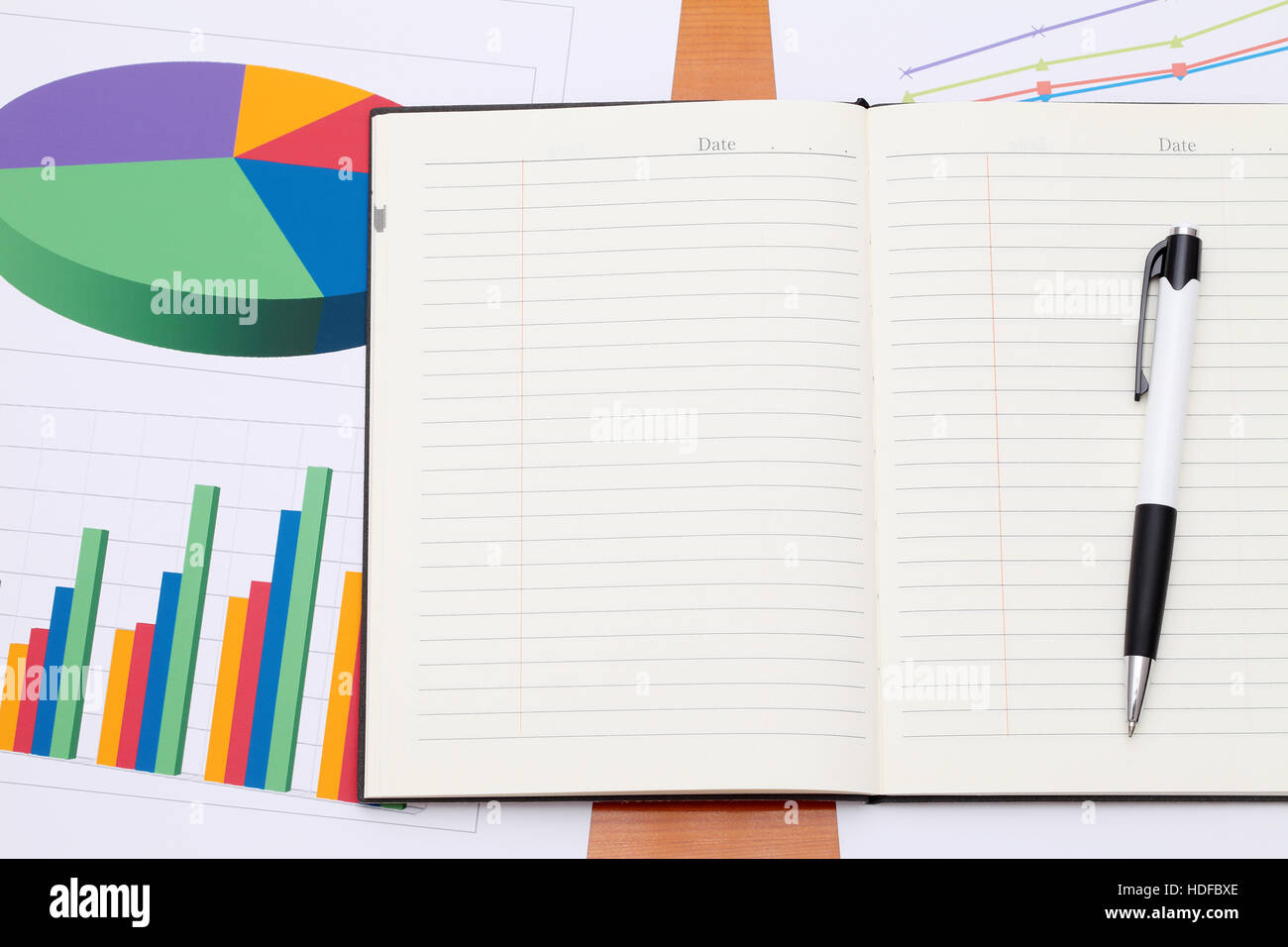 Opened notebook with ballpoint pen, chart documents on the desk Stock ...