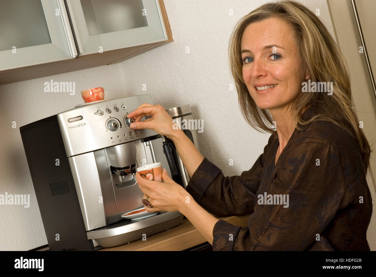 Blond woman making a coffee Stock Photo - Alamy
