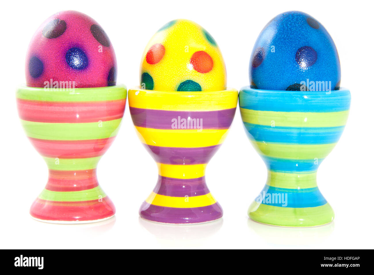 Colorful spotted eggs in striped eggcups isolated over white Stock ...