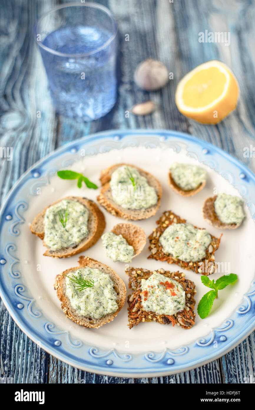 Plate with different bread with tzatziki on the blue table vertical ...