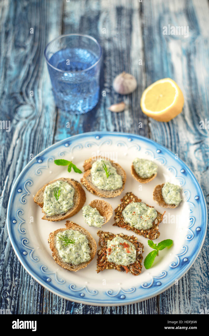 Plate with different bread with tzatziki on the blue table Stock Photo ...