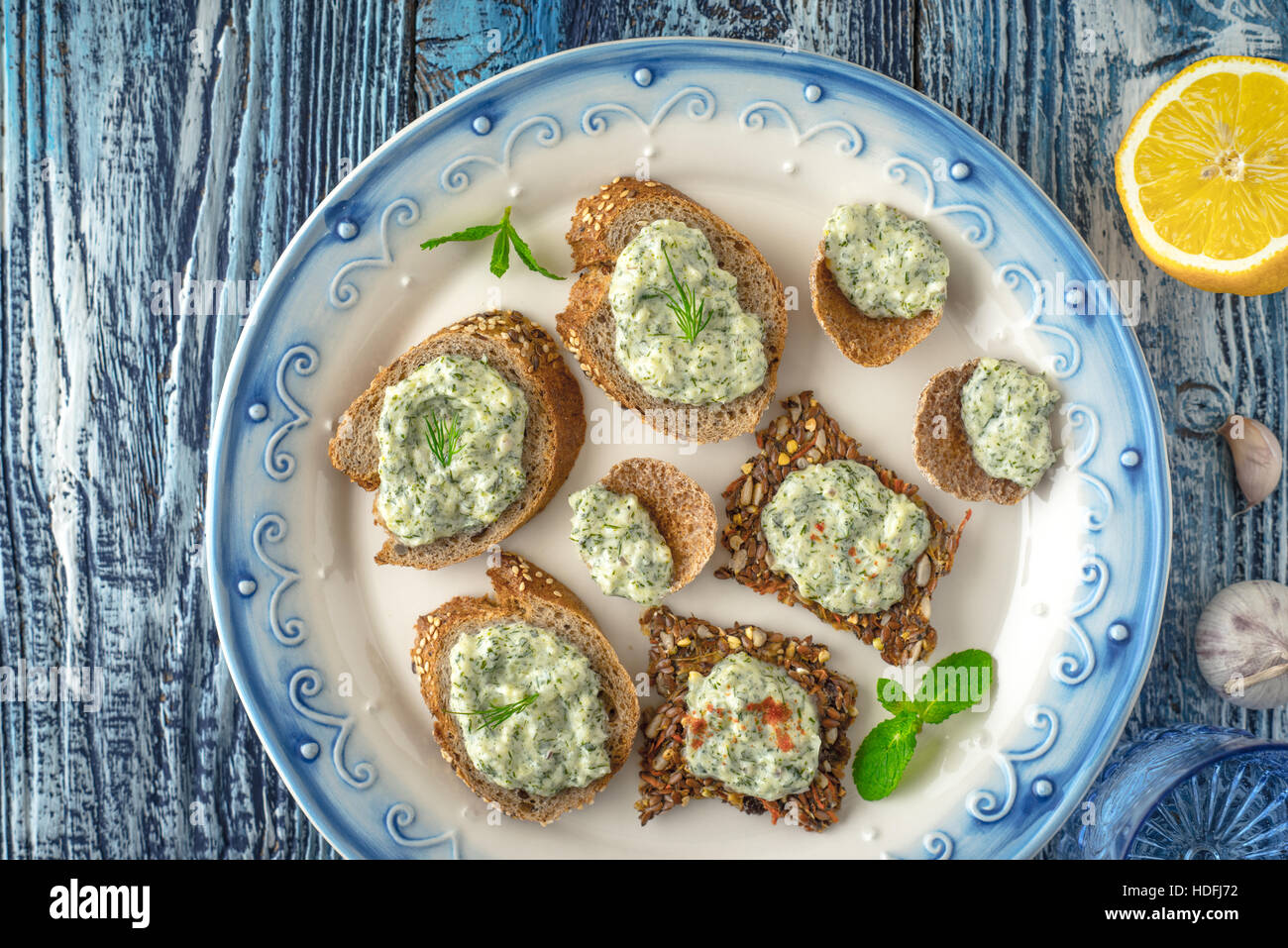 Plate with different bread with tzatziki on the blue table top view ...