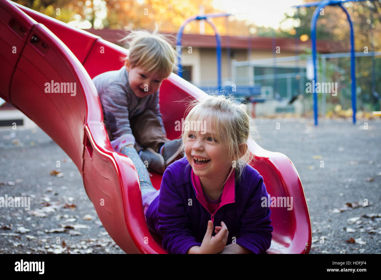 adorable brother and sister siblings playing together on slide at ...