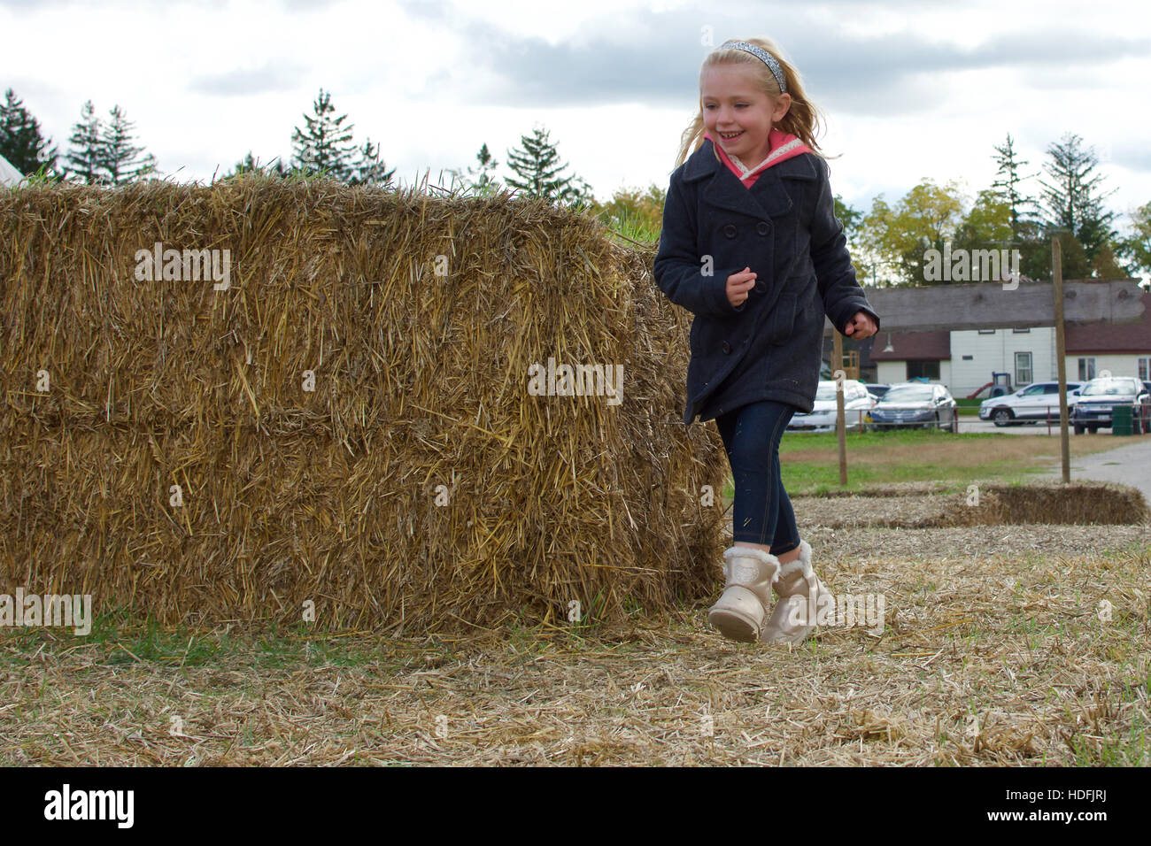 adorable school age girl running around haystacks on farm in fall ...