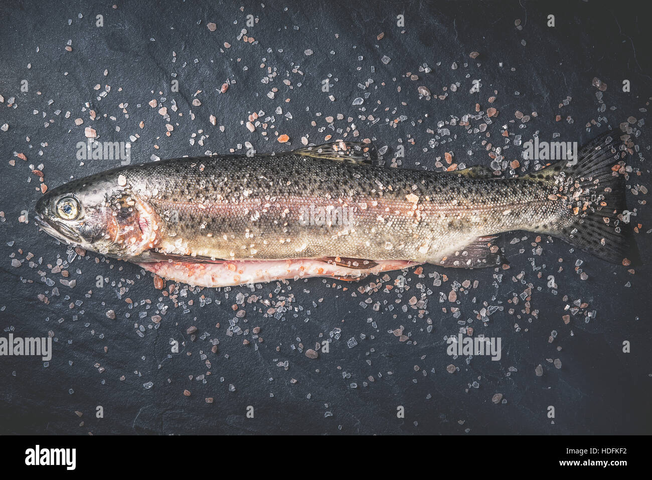 Raw trout with salt on the dark stone background top view Stock Photo ...