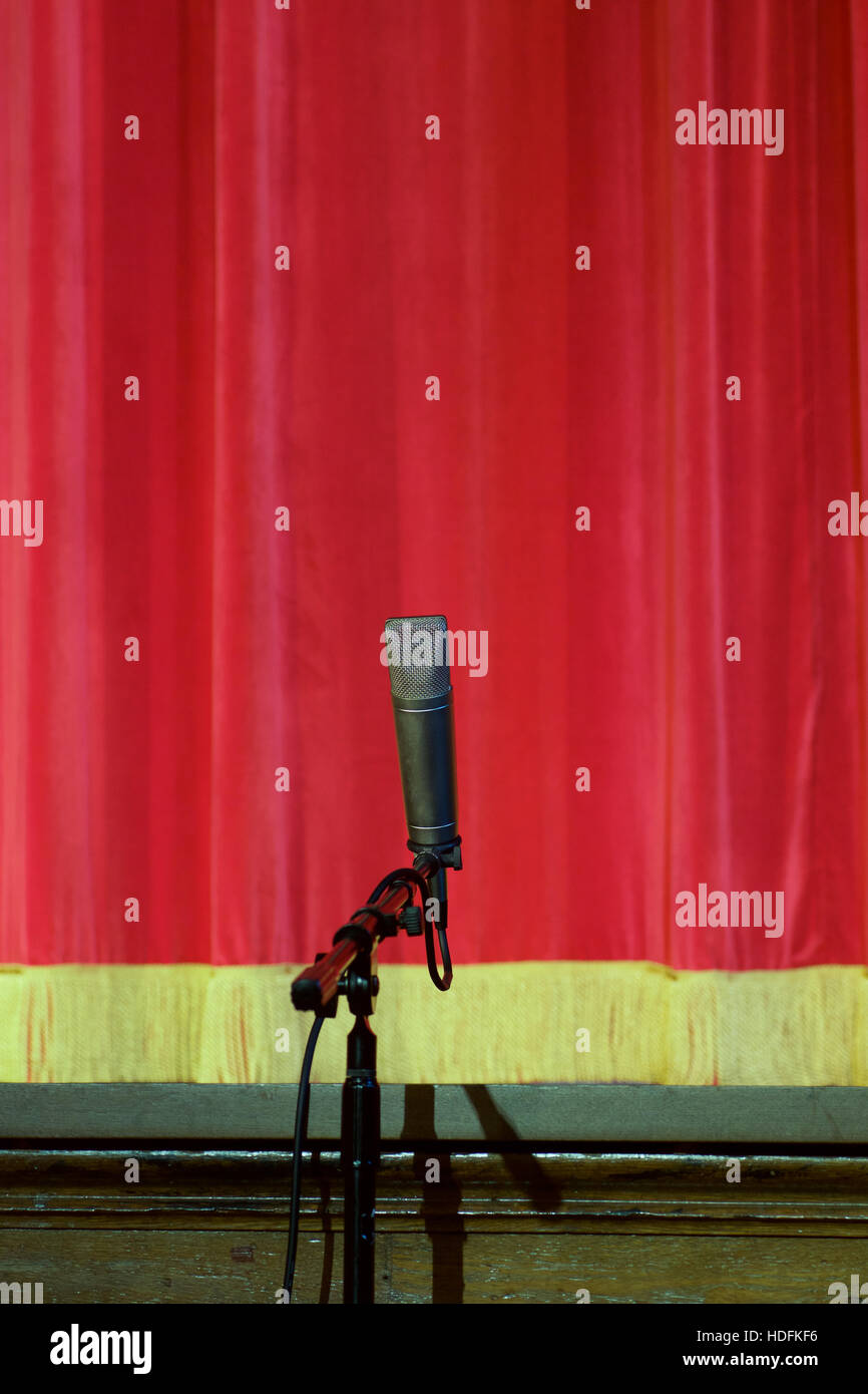 single microphone in front of red stage curtain Stock Photo - Alamy