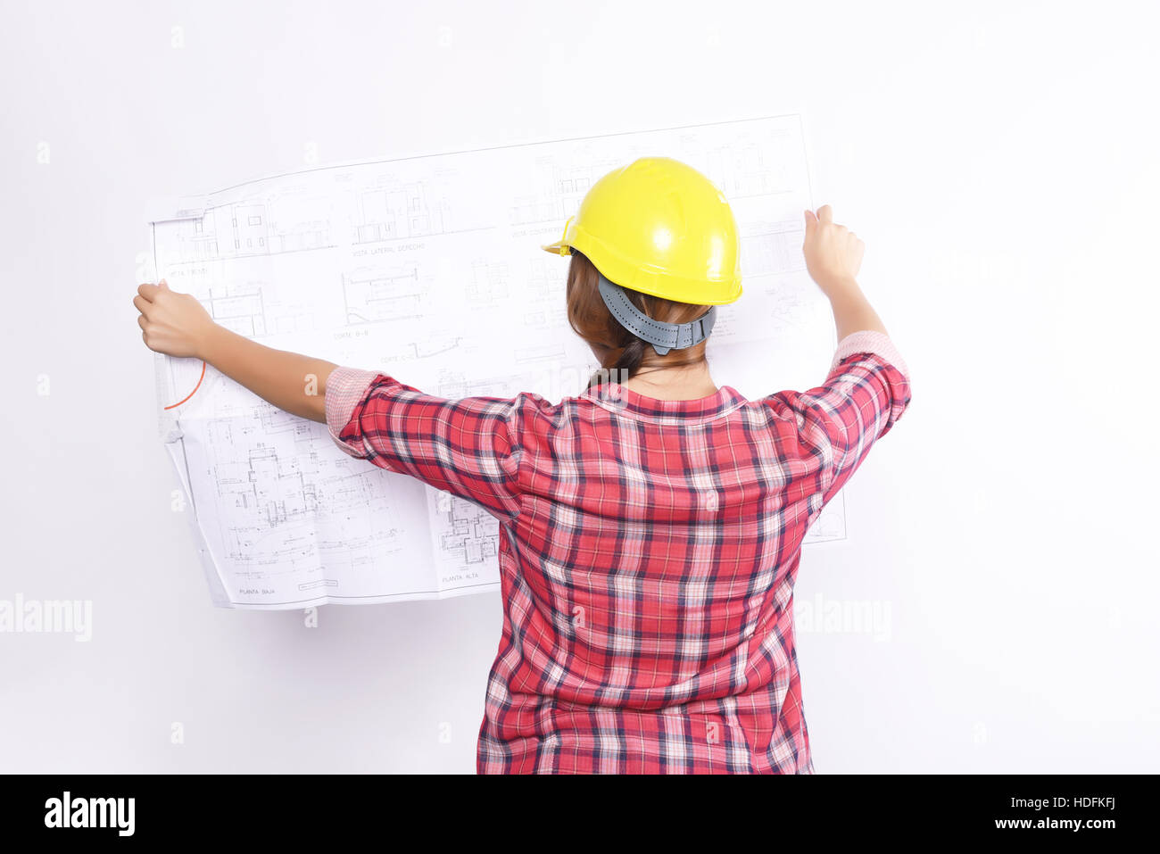 Portrait of beautiful woman construction worker reading blueprints ...