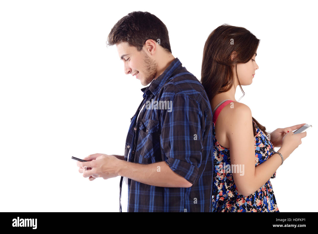 Portrait of a young beautiful couple sending messages with smartphones ...