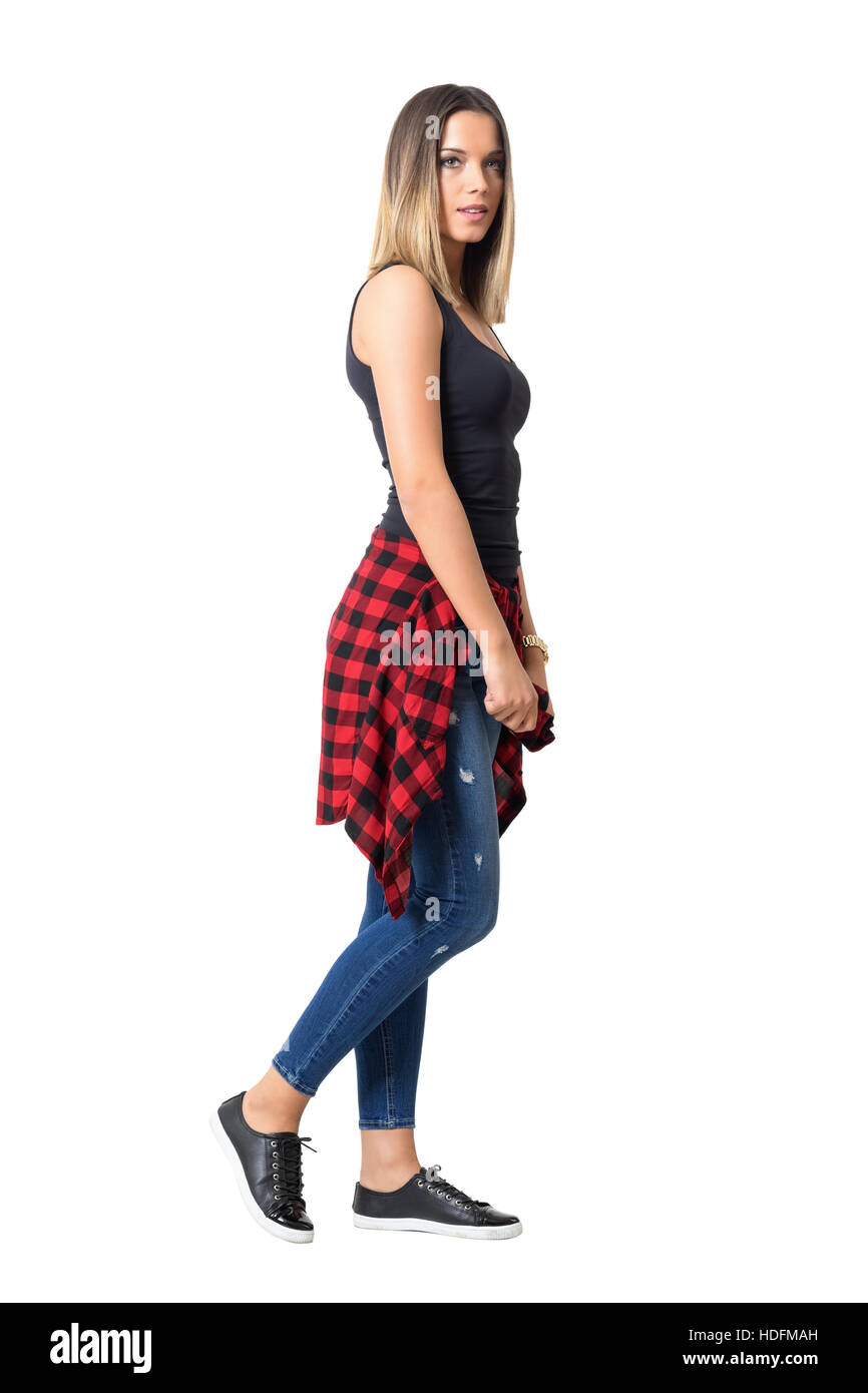 Side view of young serious woman walking with shirt around waist ...