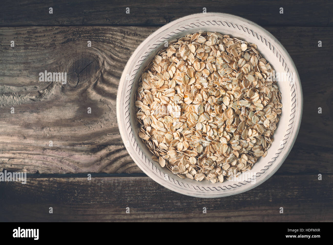 Raw oatmeal in the bowl on the wooden table top view Stock Photo - Alamy