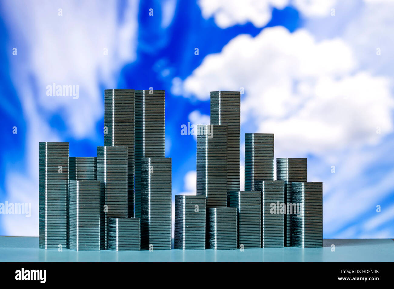 Staples arranged to form city skyline on a blue sky with white clouds ...