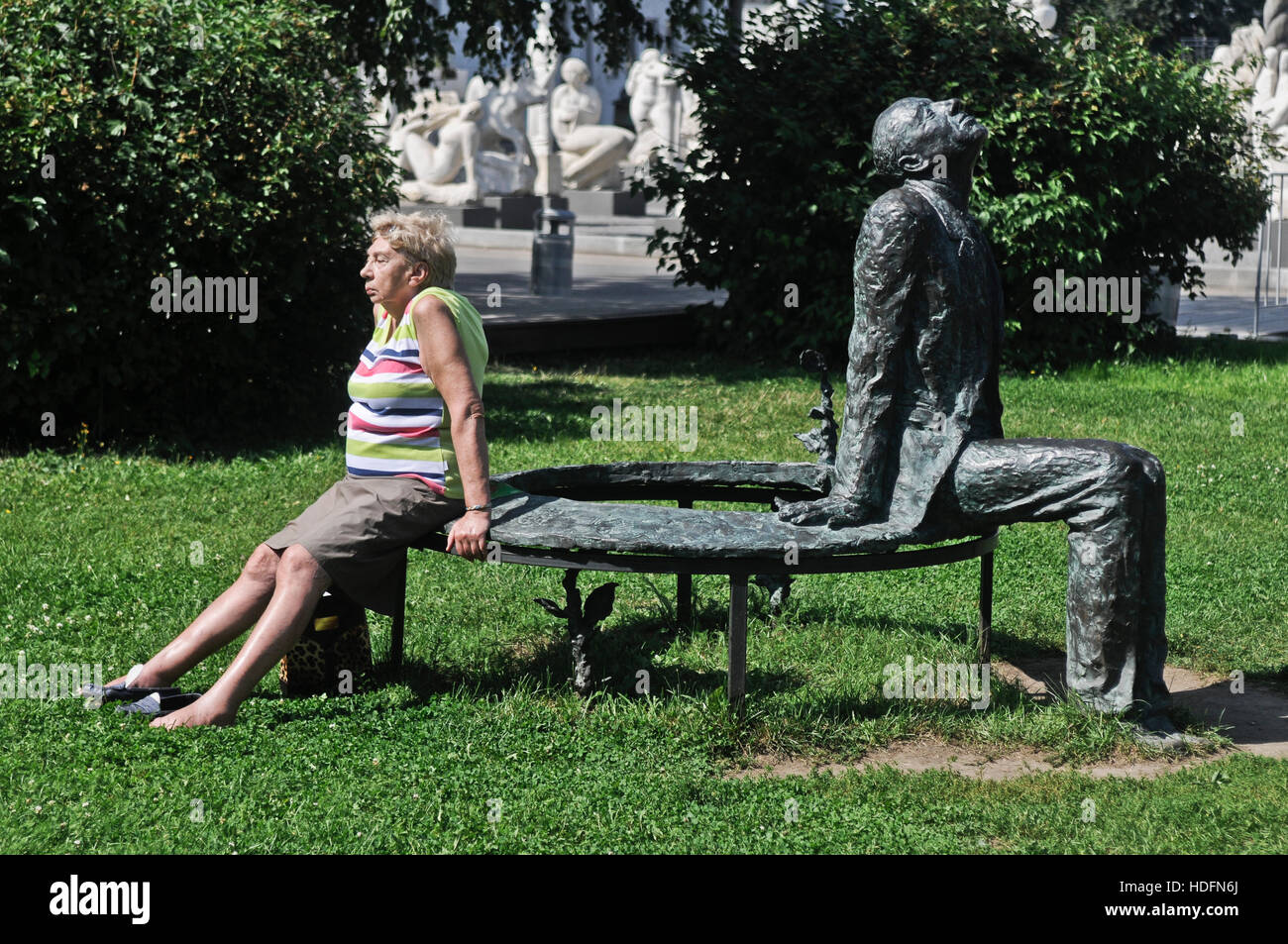 Russian old woman sitting beside the Andrei Sakharov statue, with ...