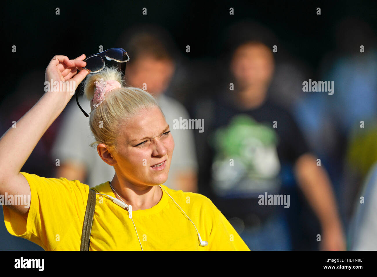 Blonde woman taking off her sunglasses on the street Stock Photo - Alamy