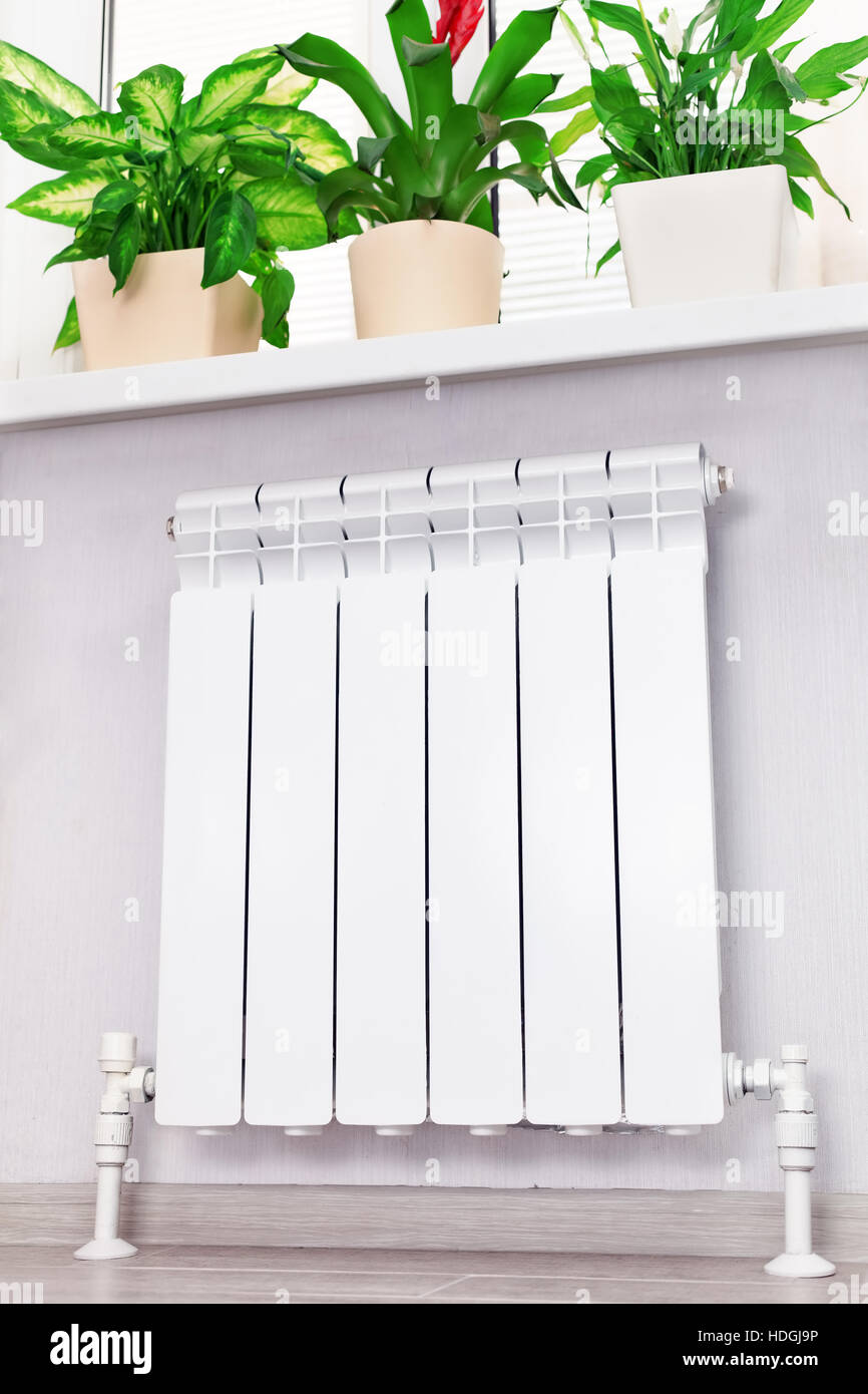 Heating white radiator radiator with flower and window Stock Photo - Alamy