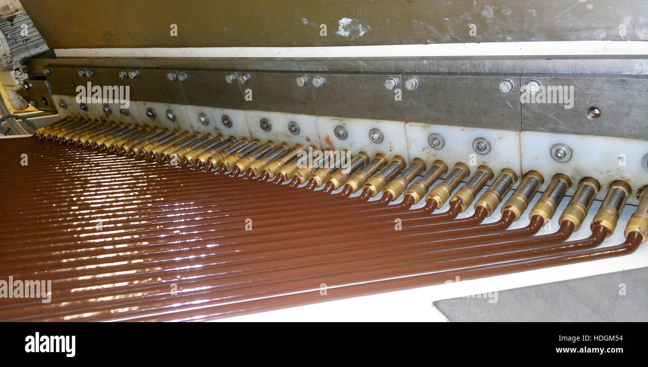 Flowing warm chocolate for candy bars production Stock Photo - Alamy