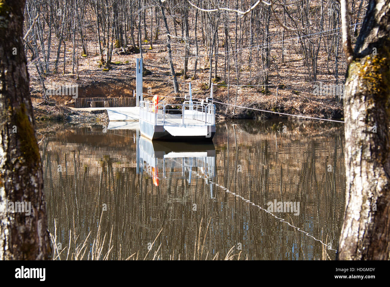 Crossing over water with little ferry by hand in forest Stock Photo - Alamy