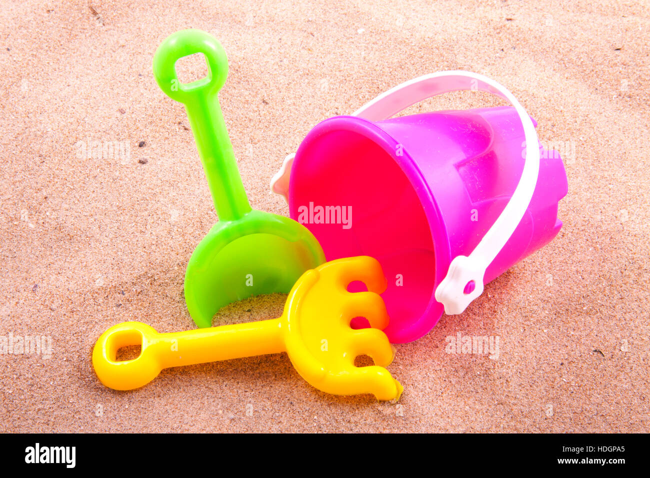 Colorful beach toys on a sand background Stock Photo - Alamy