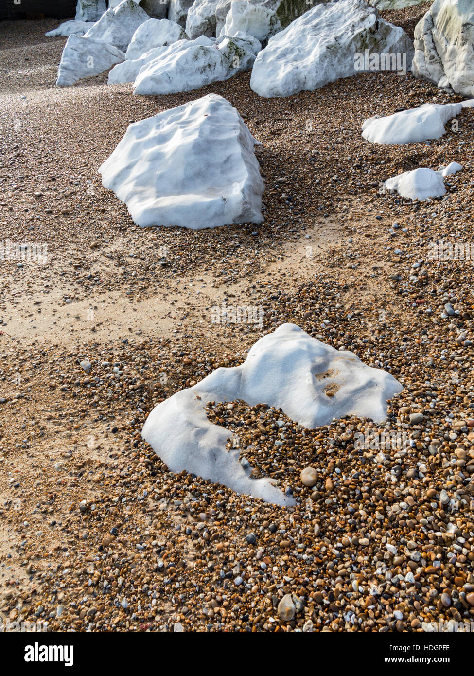 Sea defense boulders on a pebble beach beautifully worn and shaped by ...