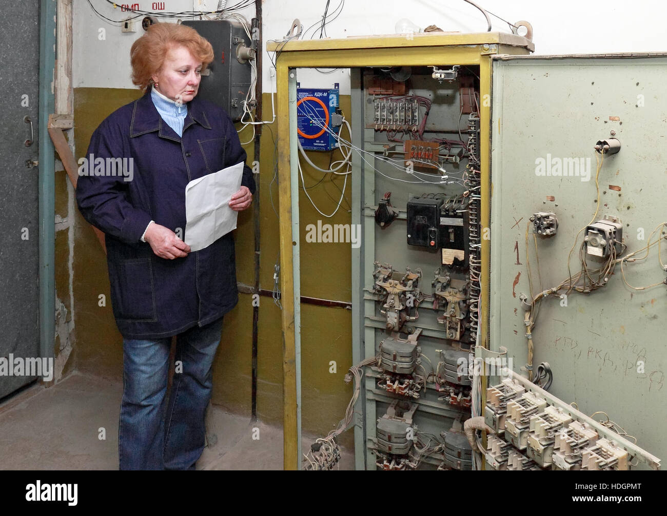 Operator woman-engineer in machine room (elevator) check the mechanical ...