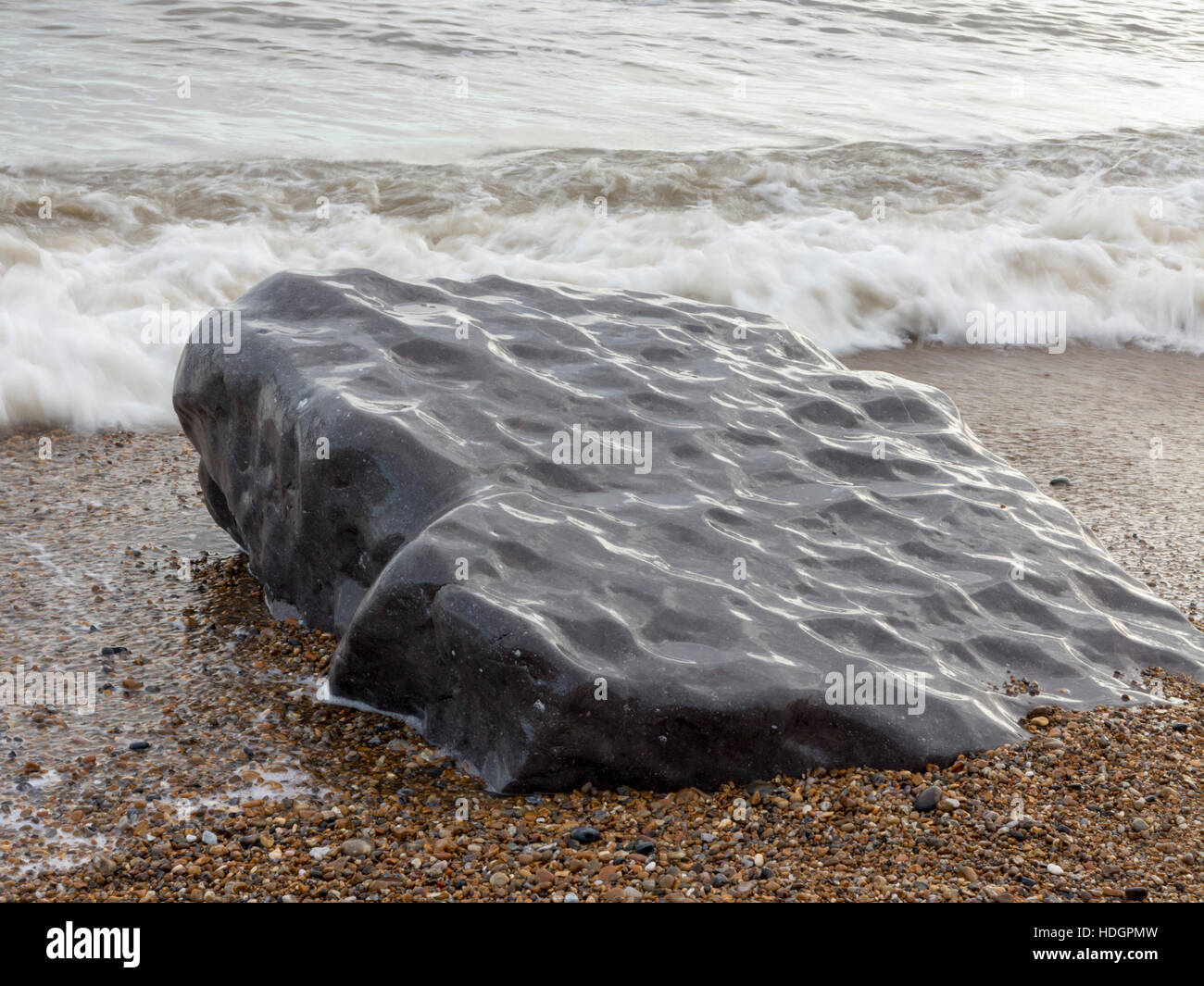Sea defense boulders on a pebble beach beautifully worn and shaped by ...