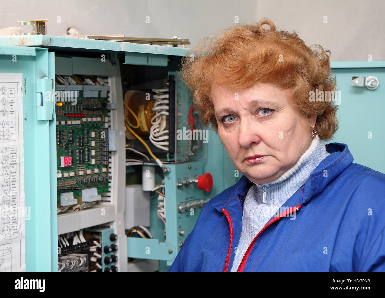 Operator woman-engineer in machine room (elevator) near electronic ...