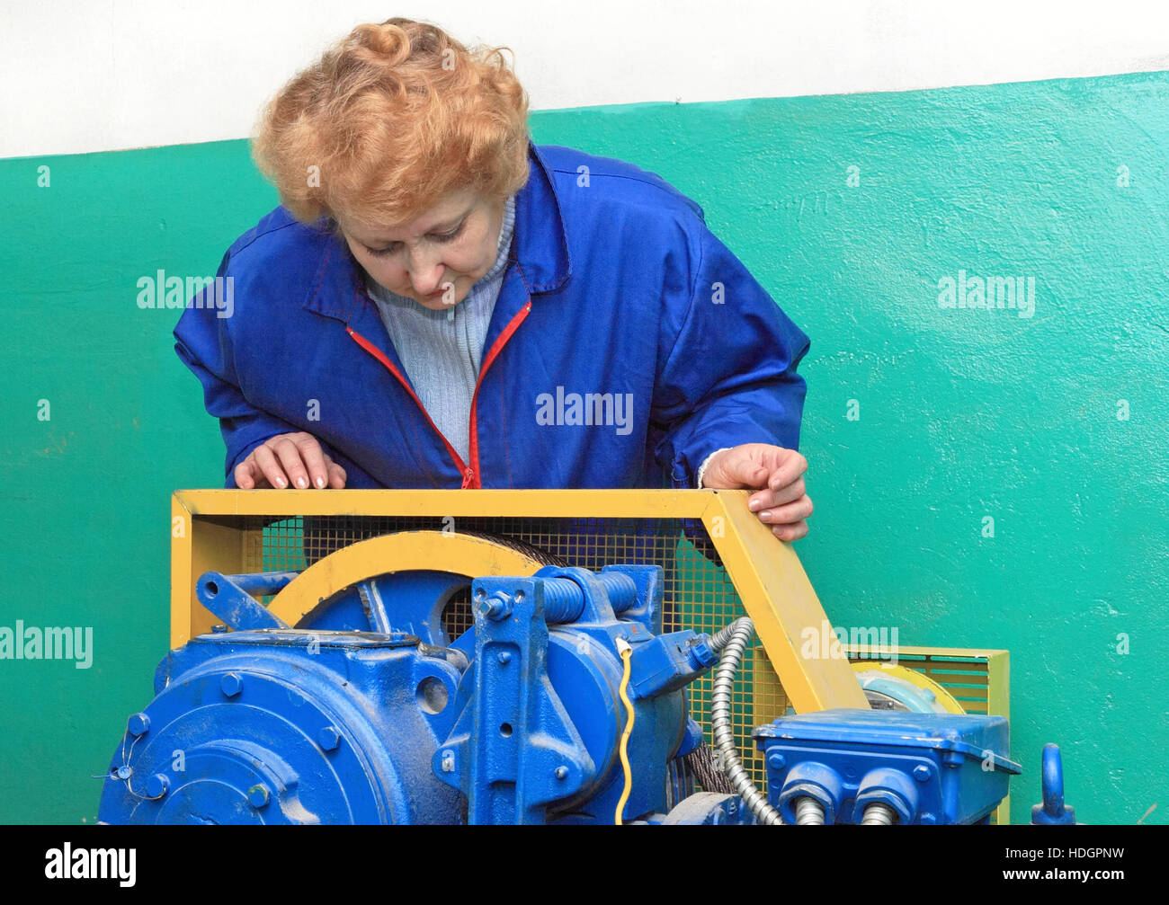Operator woman-engineer in machine room (elevator) check the mechanical ...