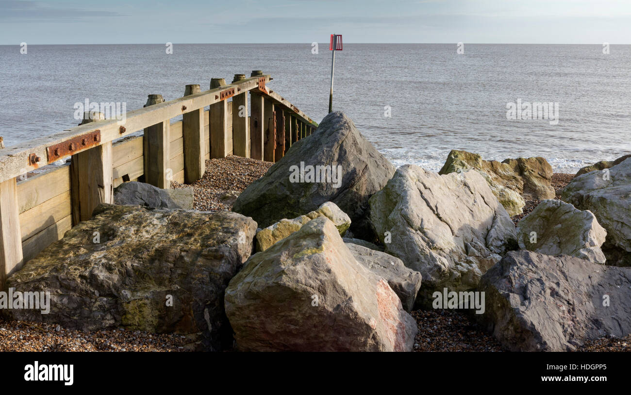Wooden groynes running from a shingle beach into the sea with horizon ...