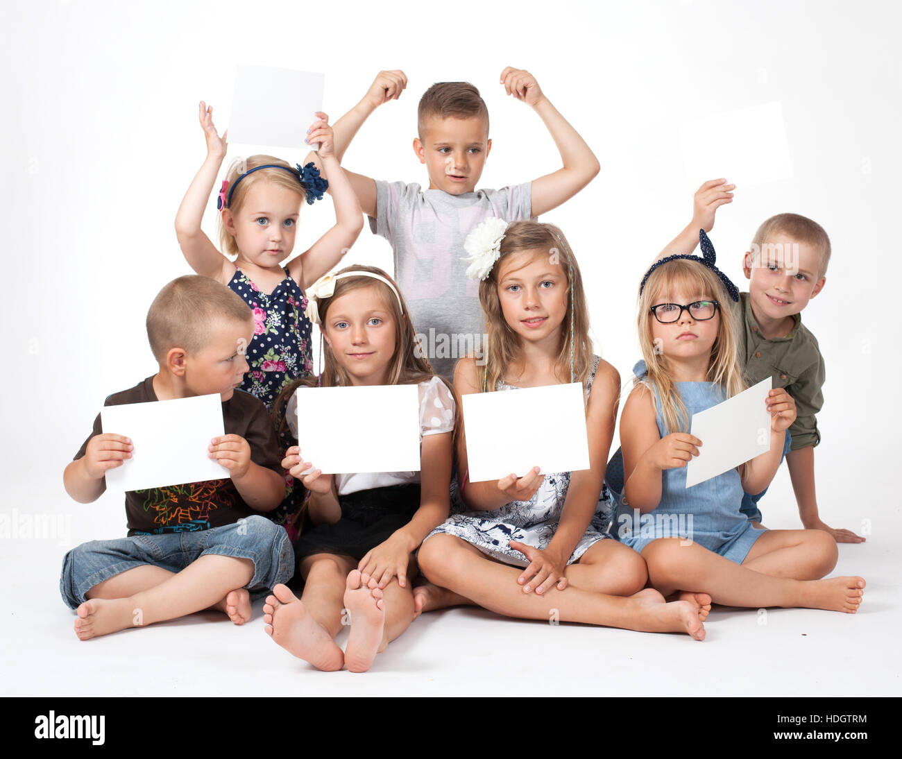 a group of children holding white card Stock Photo - Alamy
