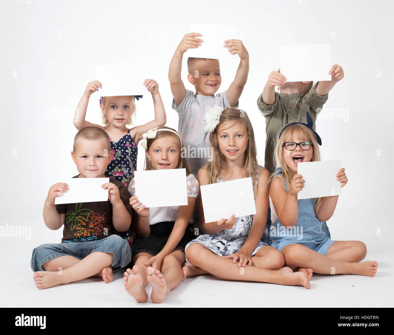 a group of children holding white card Stock Photo - Alamy