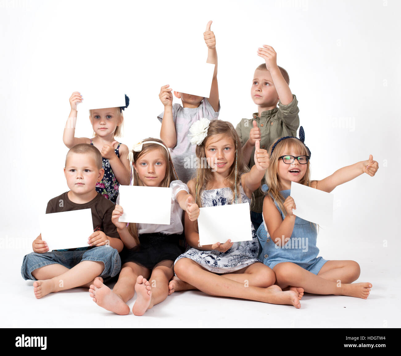 a group of children holding white card Stock Photo - Alamy