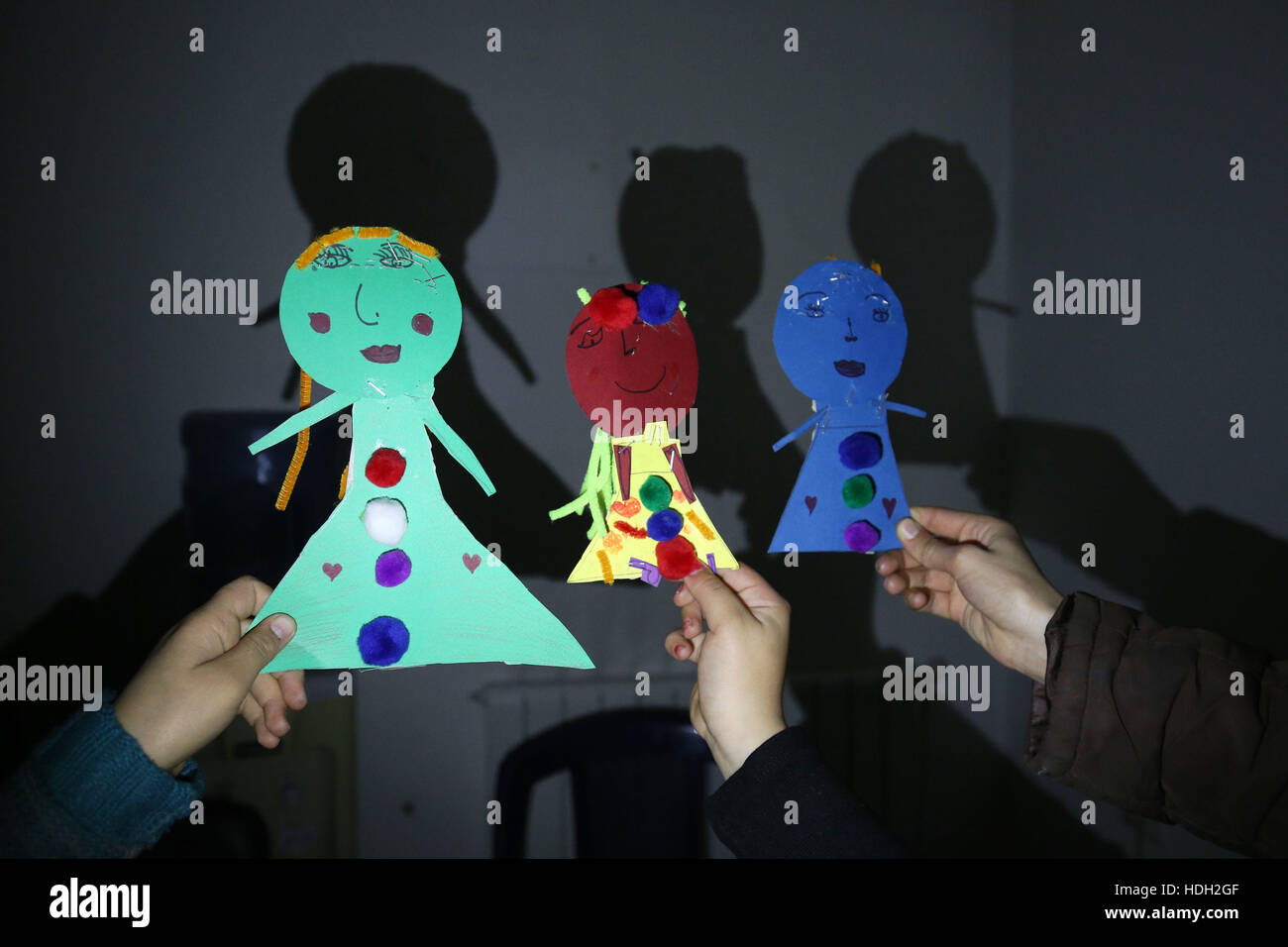 Syrian refugee children hold paper puppets made during an art therapy ...