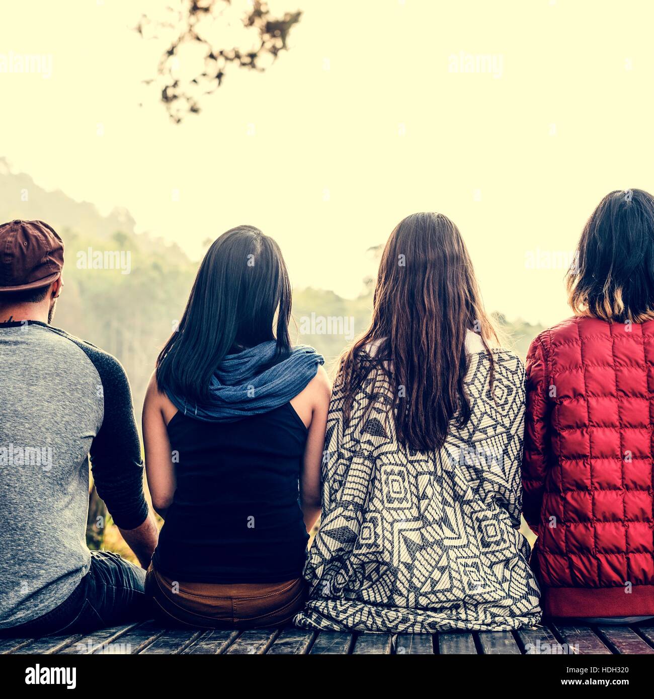 Friends Sitting in a Row Outdoors Concept Stock Photo - Alamy