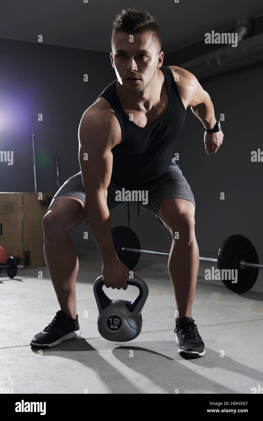 Man lifting kettlebell with one hand Stock Photo - Alamy