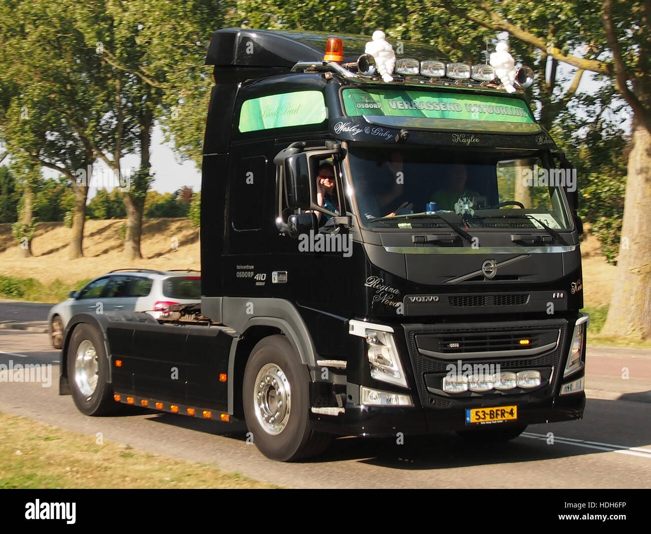 This image depicts a large truck being used for vehicle transport, a ...