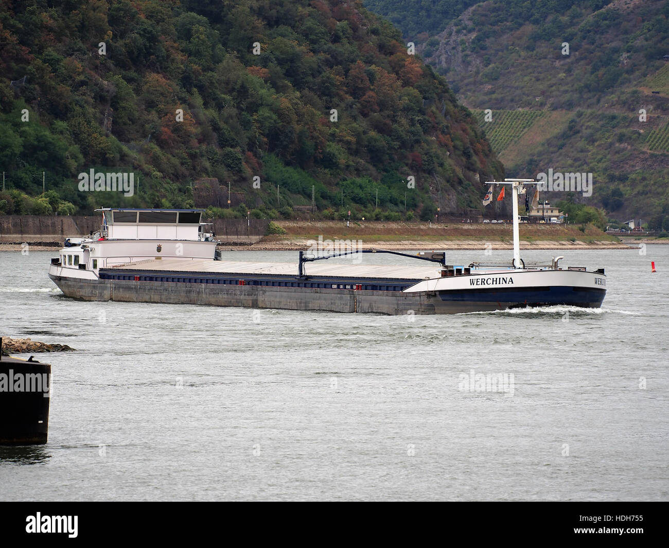 A boat navigates the river Rhine, captured in a scenic photograph ...